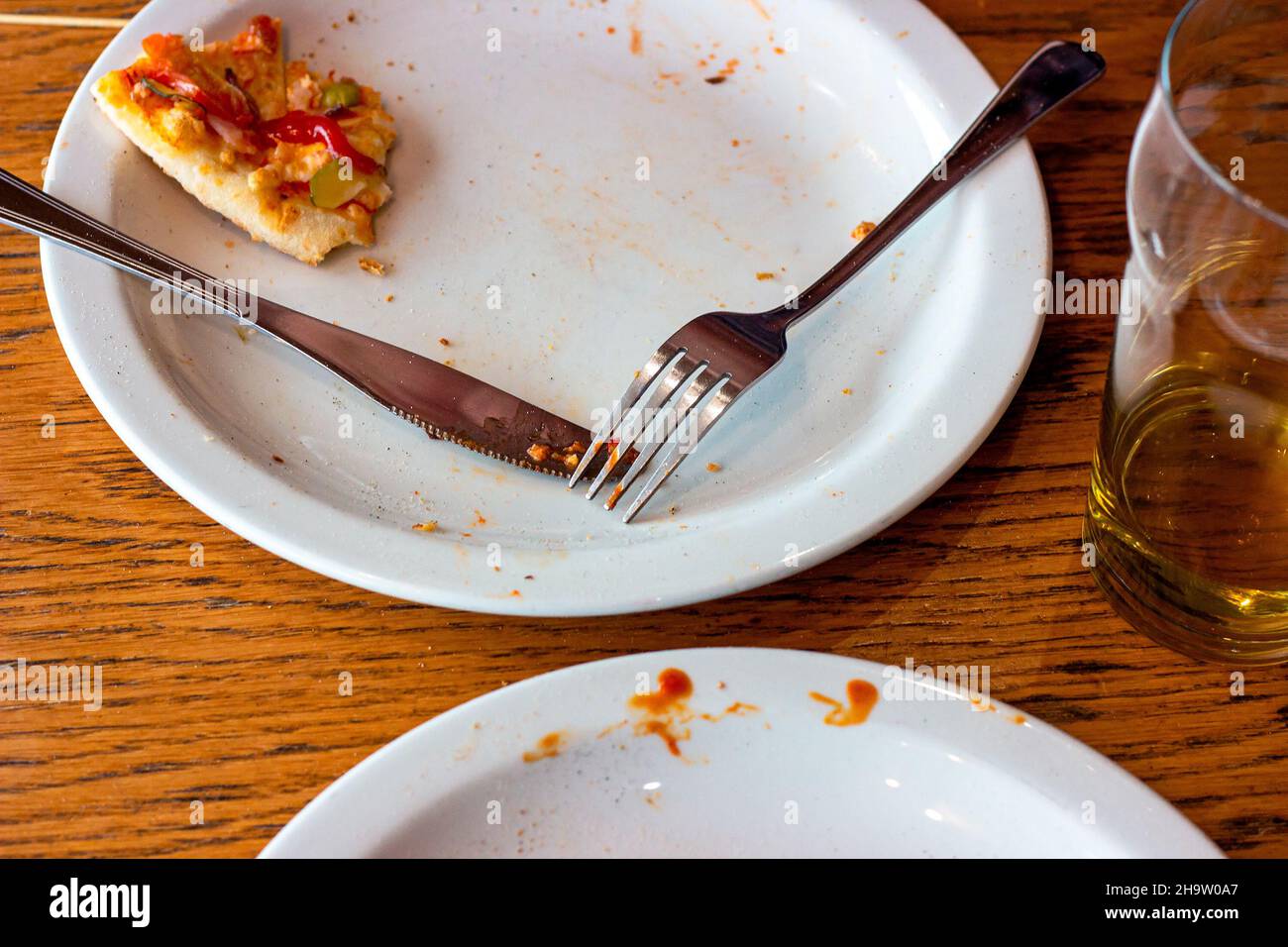 Dirty messy plates after pizza eating with unclean used utensils in the ...