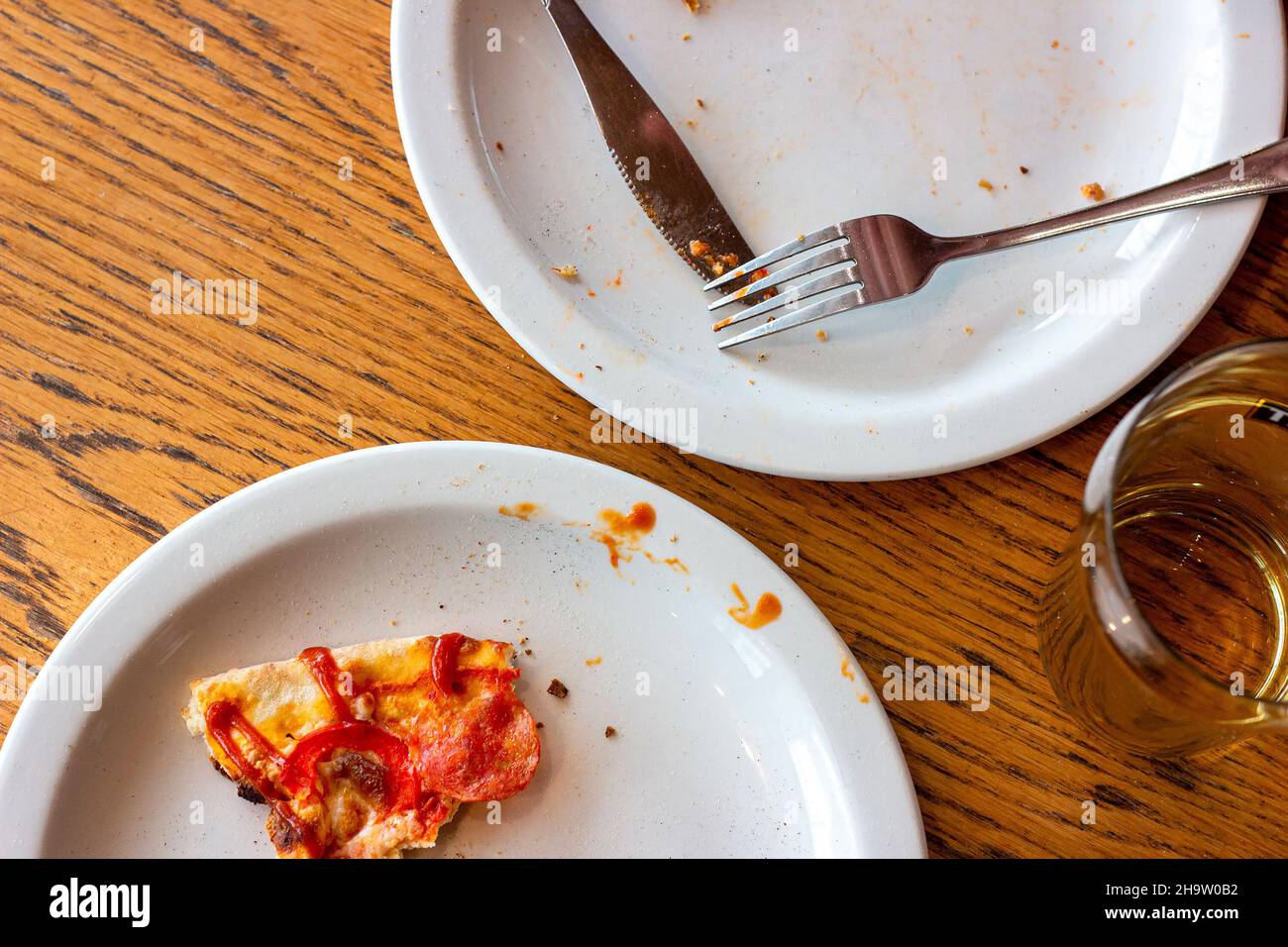 Top view of dirty messy plates after pizza eating with unclean used ...