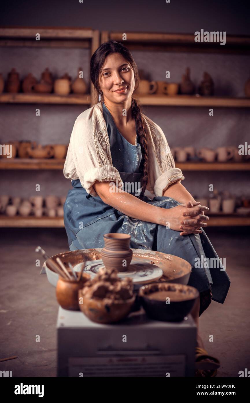 Pottery master demonstrates a finished clay bowl in the workshop ...