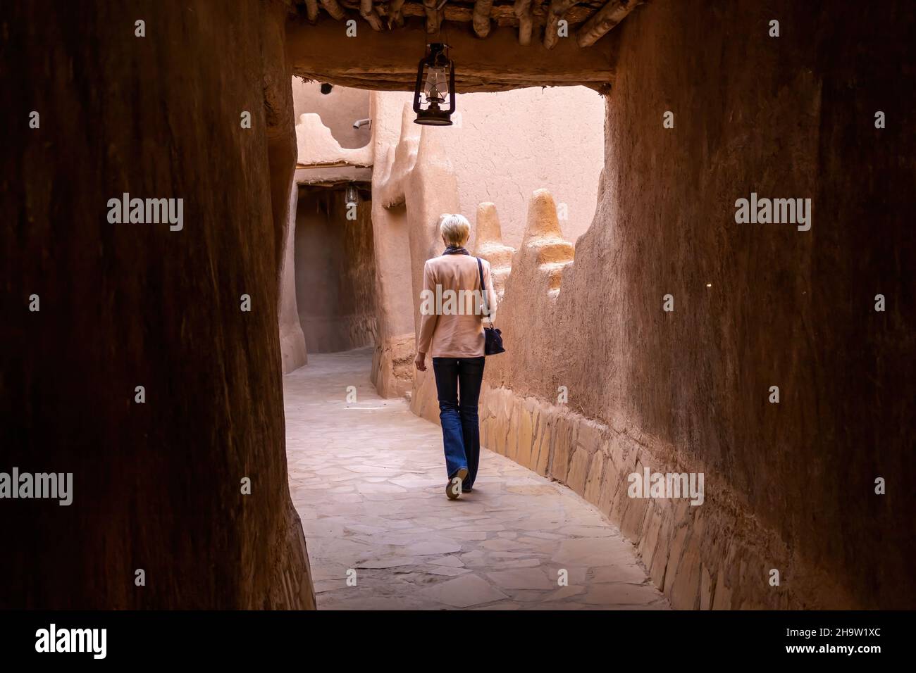 A lonely Western female tourist walking in the narrow street in ...