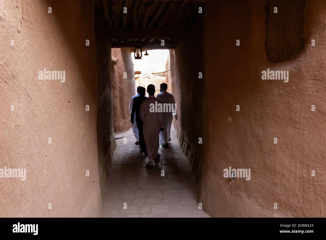Saudi men walking in the narrow covered street of Ushaiqer Heritage ...