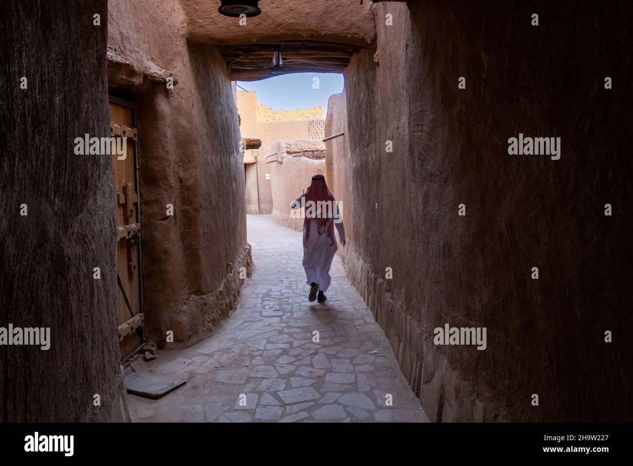 Saudi man walking in the narrow covered street of Ushaiqer Heritage ...