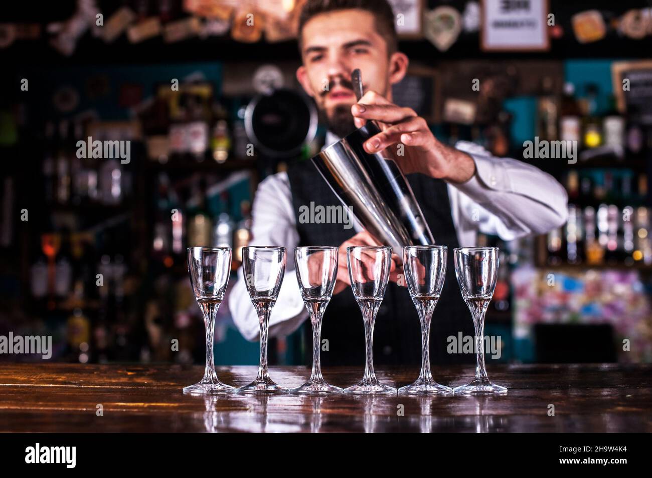 Bearded bartender intensely finishes his creation at bar Stock Photo ...