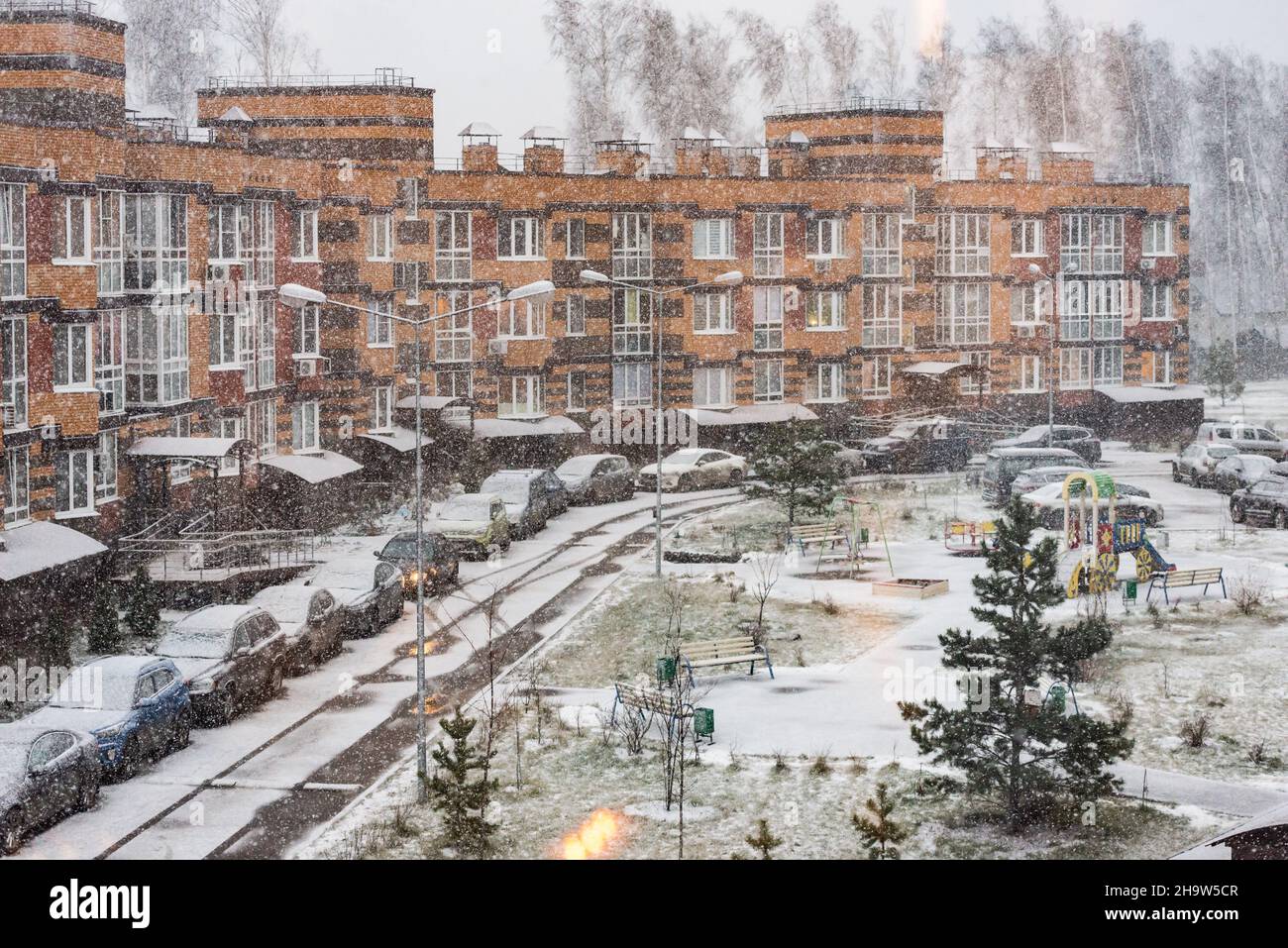 Heavy snowfall in the city. Playground and road near the house. The ...