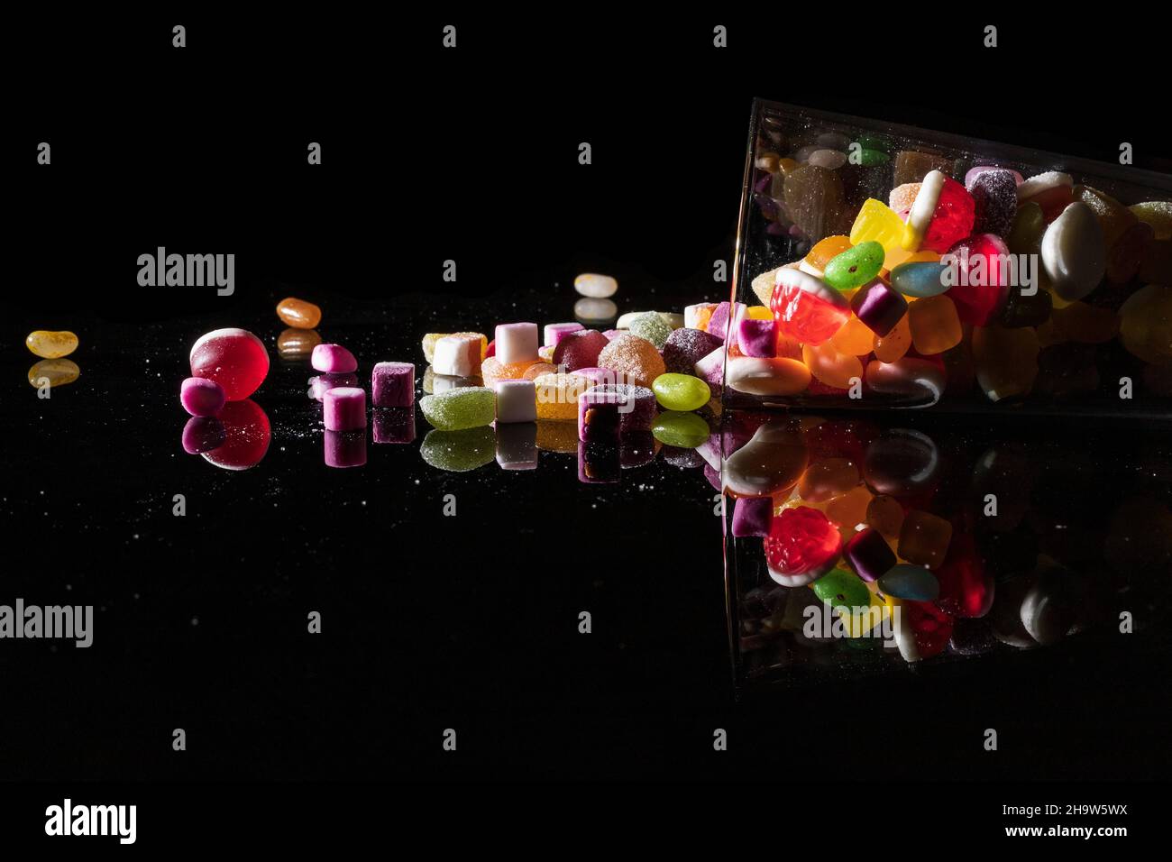 Colourful gummy sweets scattered on a glass surface Stock Photo - Alamy