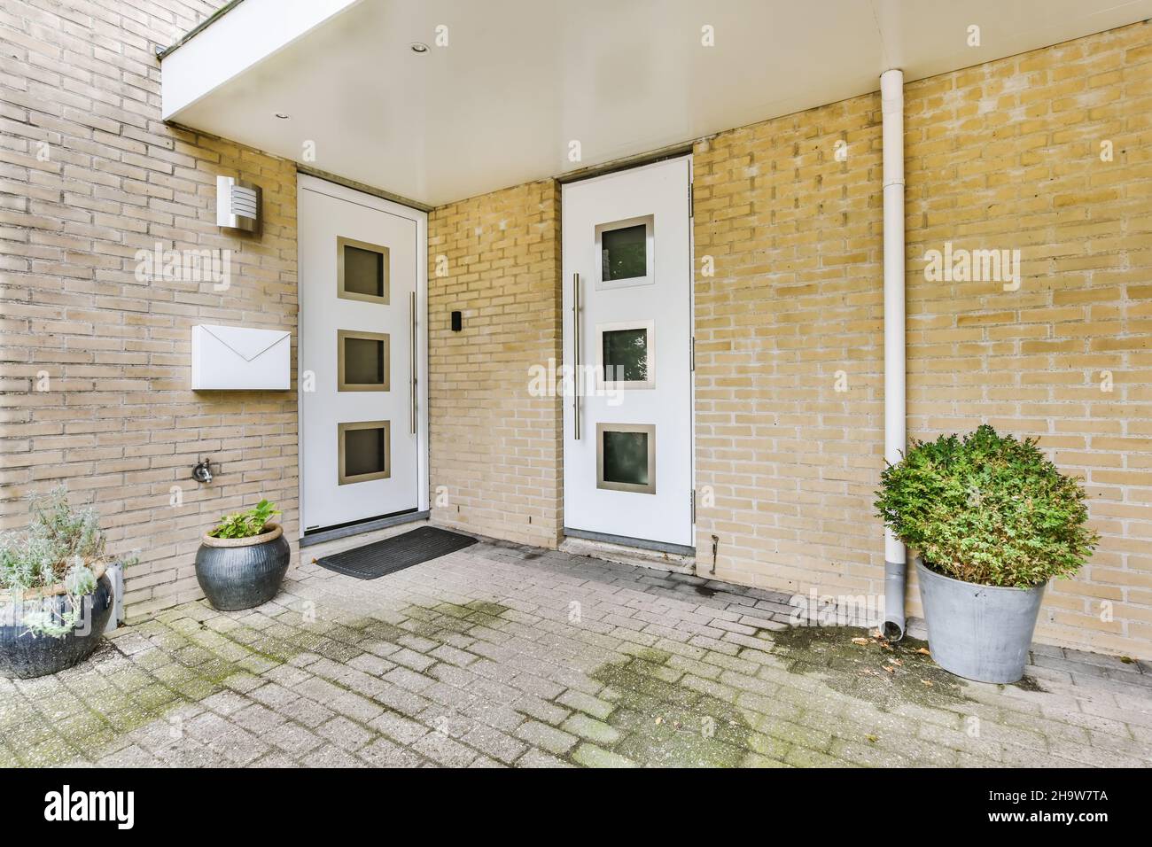 Residential building front door with white door Stock Photo - Alamy