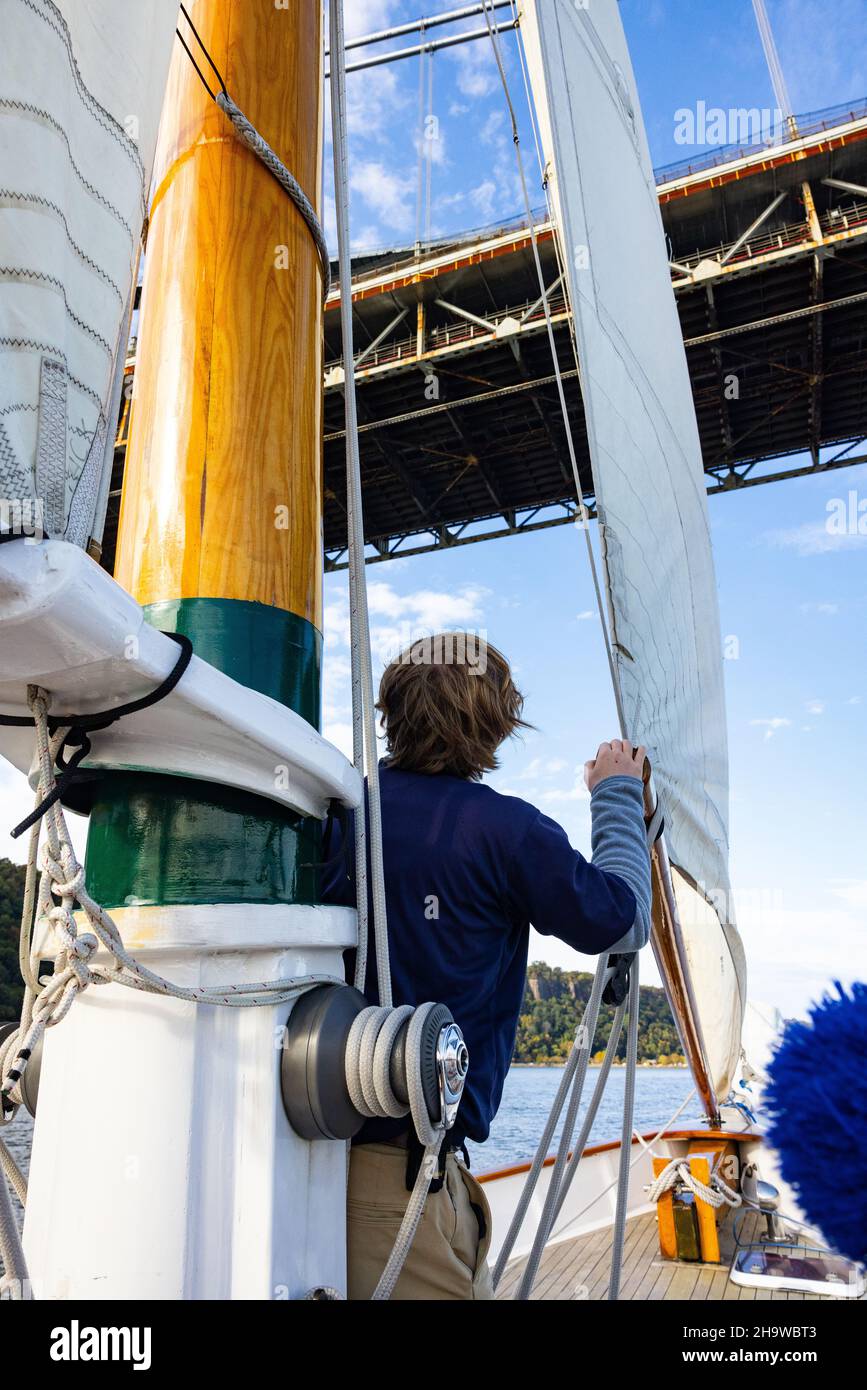 Vertical back view of a person fixing the sail of a boat Stock Photo ...