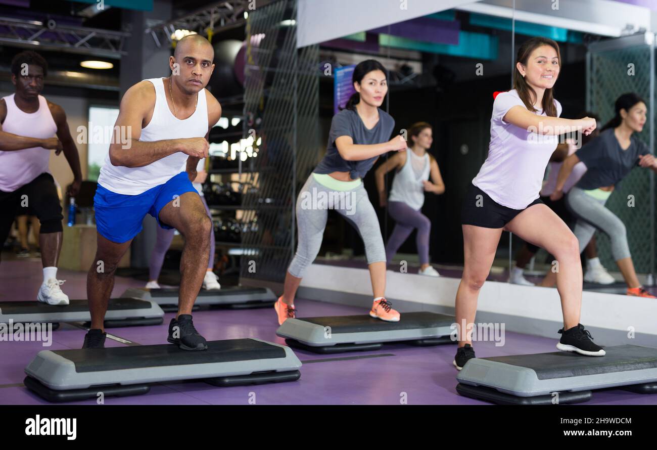 People training on step platforms in gym Stock Photo - Alamy