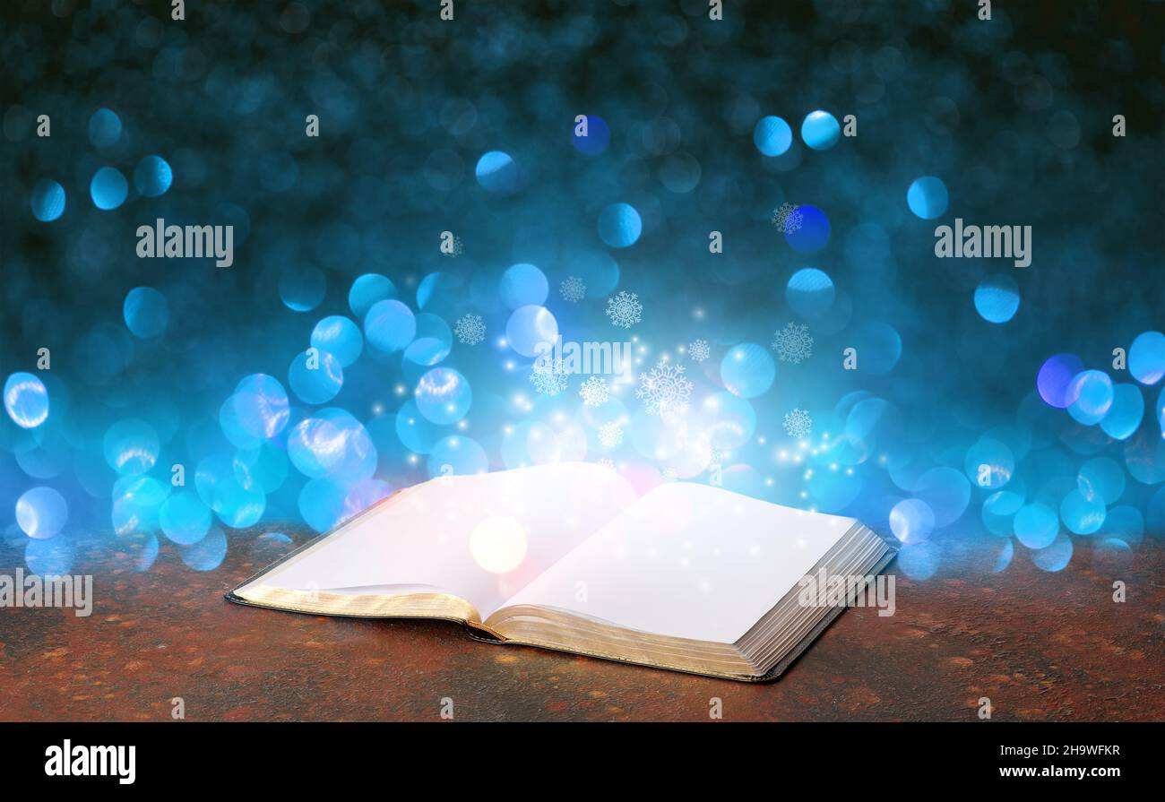 Open magic book on dark color background Stock Photo - Alamy