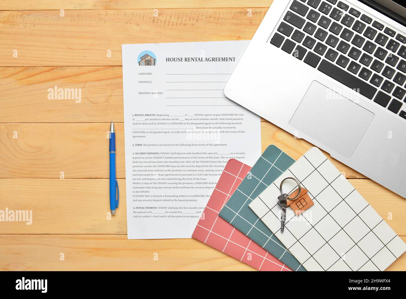 House rental agreement with notebooks, pen, key and laptop on wooden ...