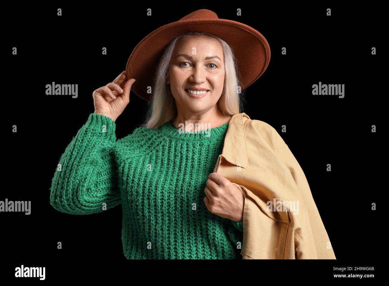Beautiful mature woman wearing felt hat on dark background Stock Photo ...