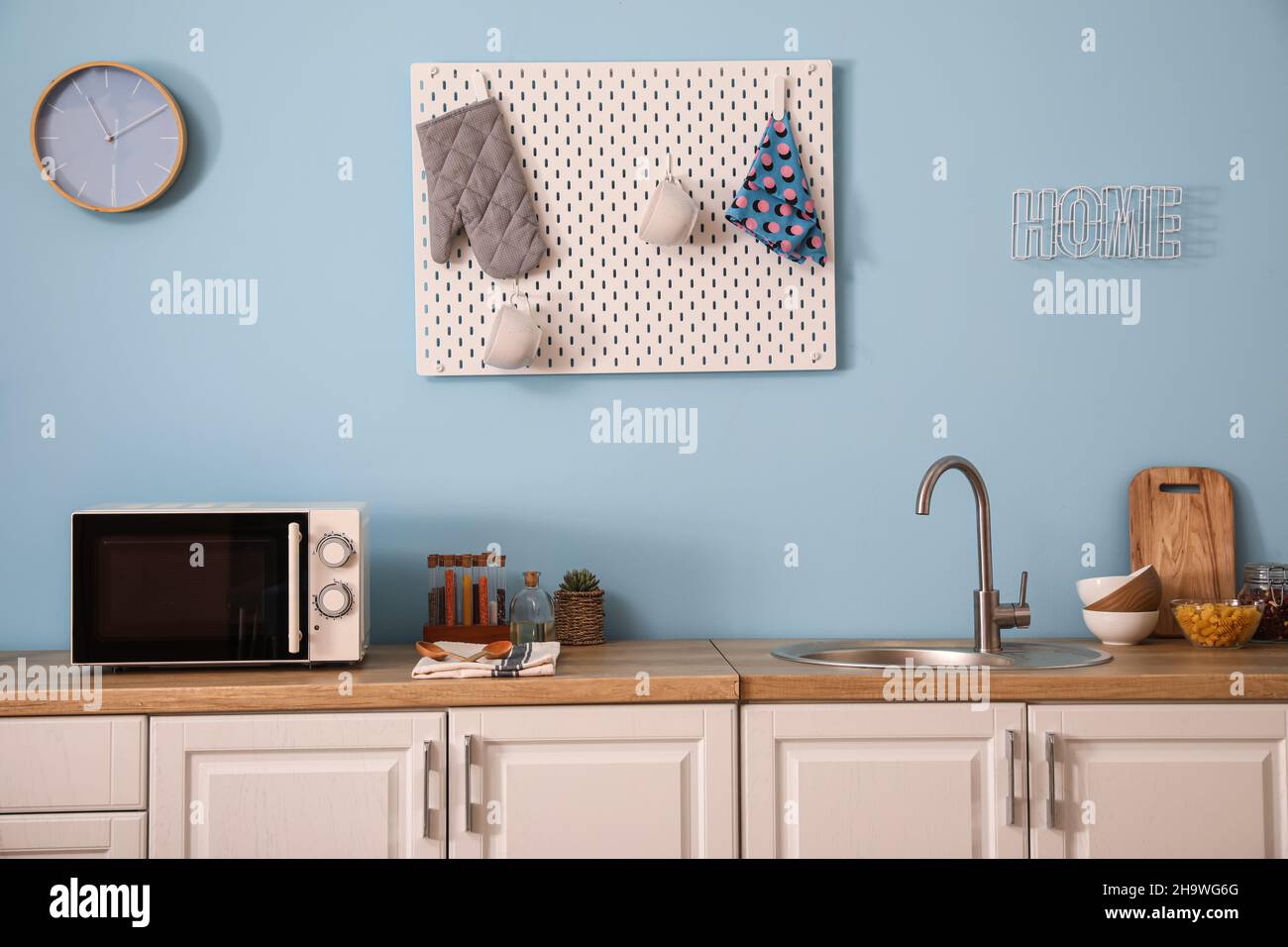 Interior of stylish kitchen with blue wall Stock Photo - Alamy