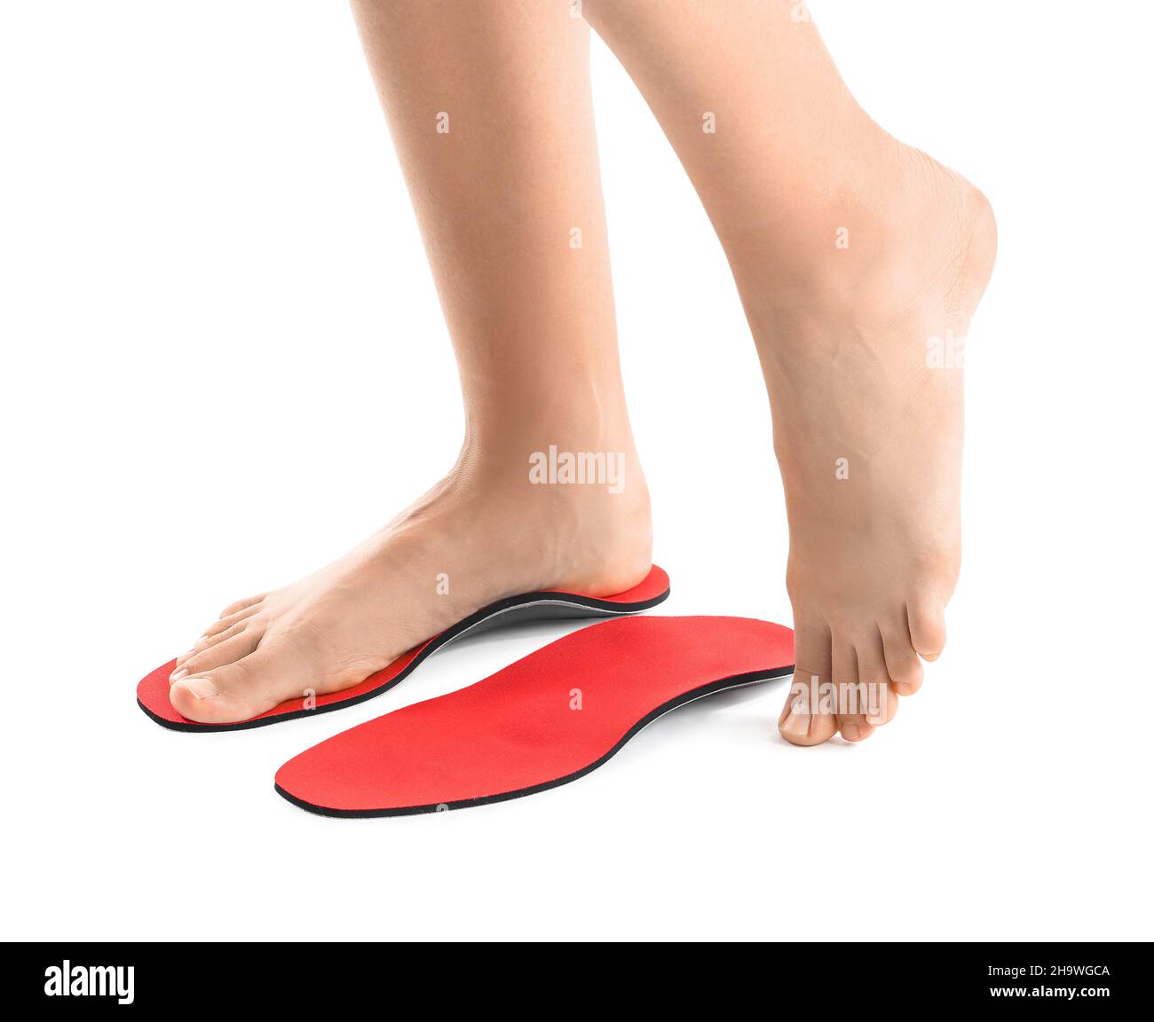 Female feet and red orthopedic insoles on white background Stock Photo ...