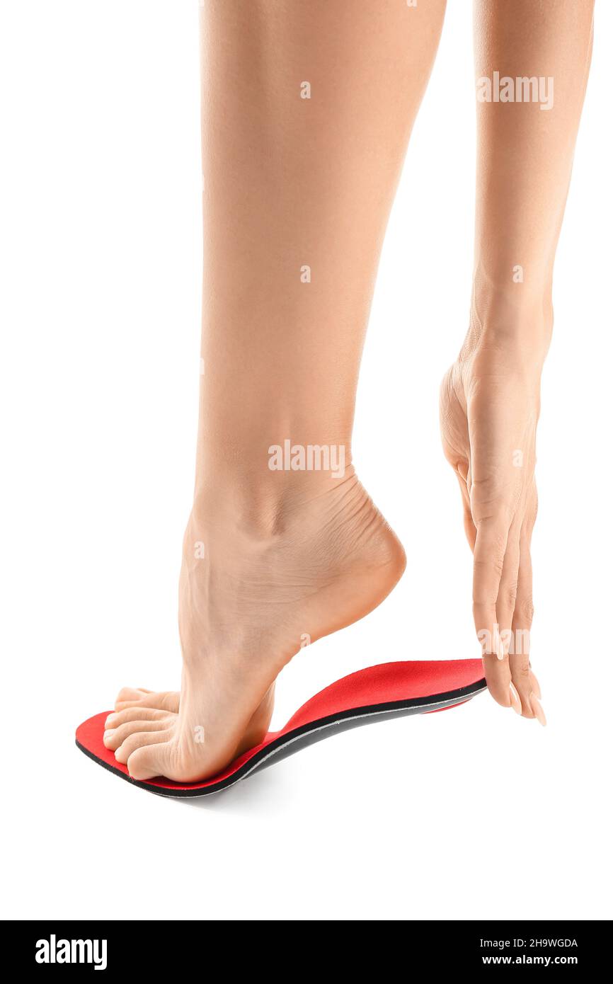Woman fitting orthopedic insole on white background Stock Photo - Alamy