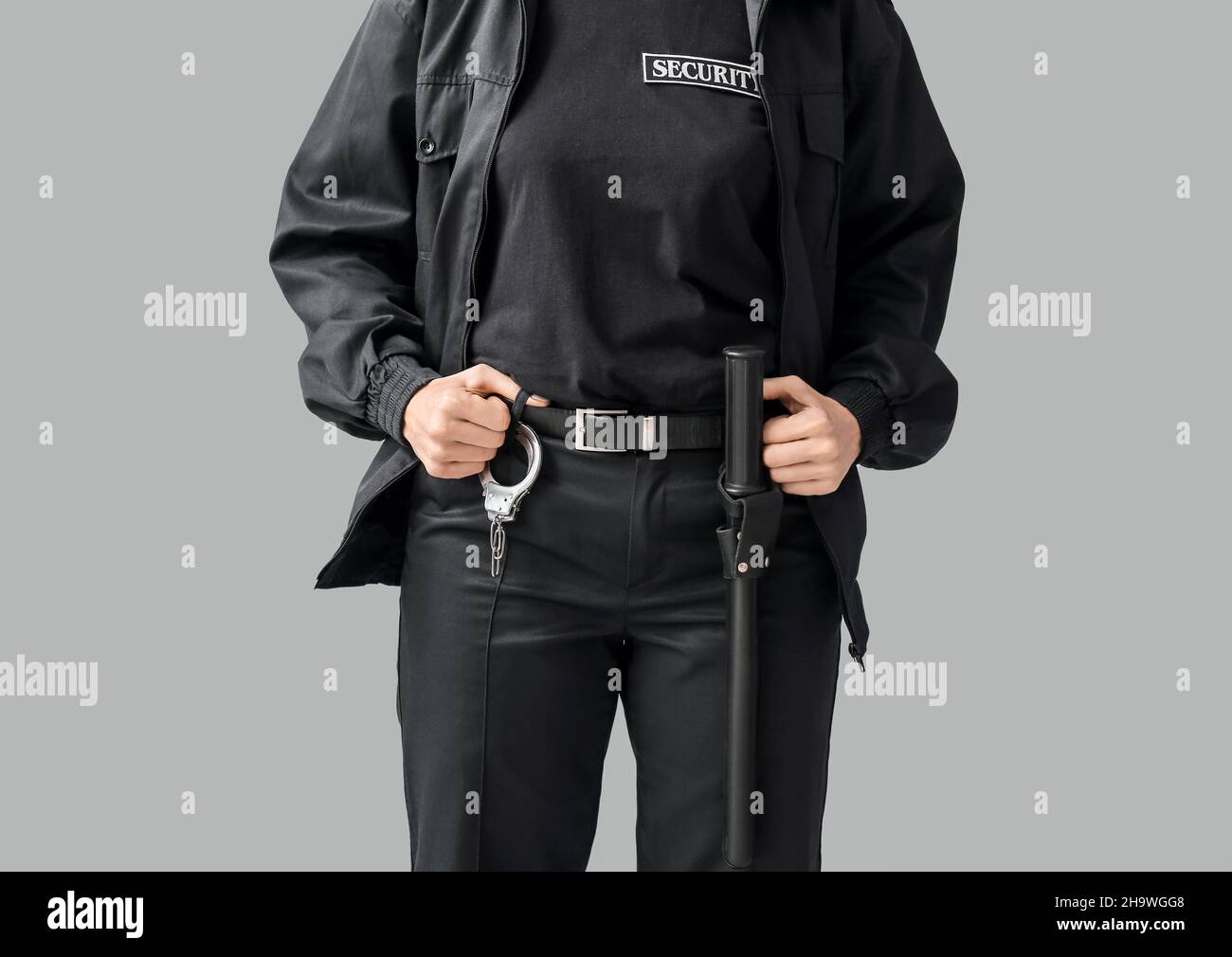 Female security guard on grey background Stock Photo - Alamy