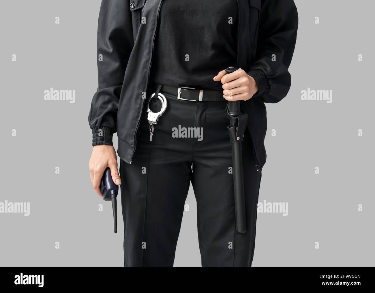 Female security guard on grey background Stock Photo - Alamy