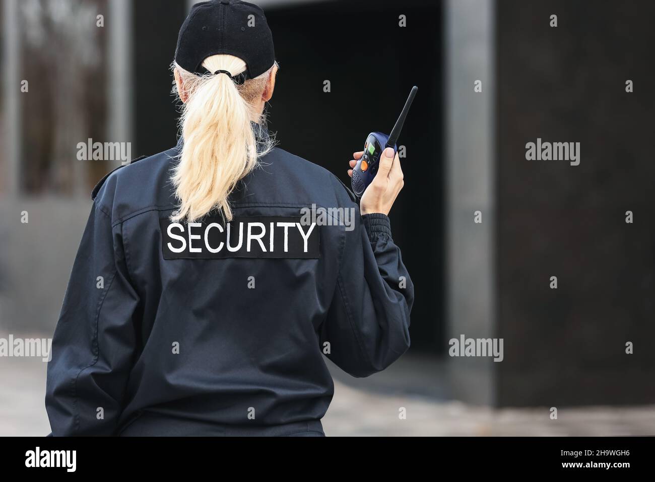 Female security guard outdoors, back view Stock Photo - Alamy