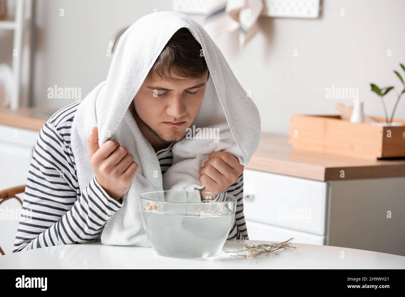 Young man doing steam inhalation at home to soothe and open nasal ...