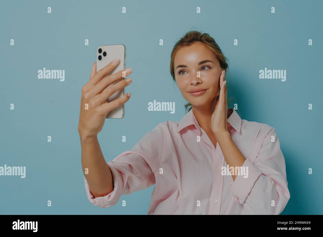 Beautiful Woman With Tender Expression Looks At Smartphone Camera Takes