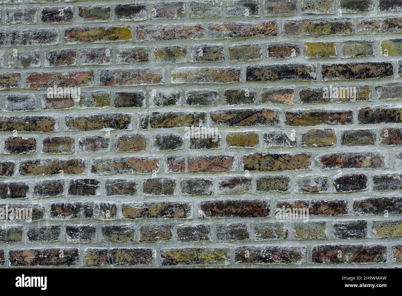 Plain background of an old brick wall with aged and discolored stones ...