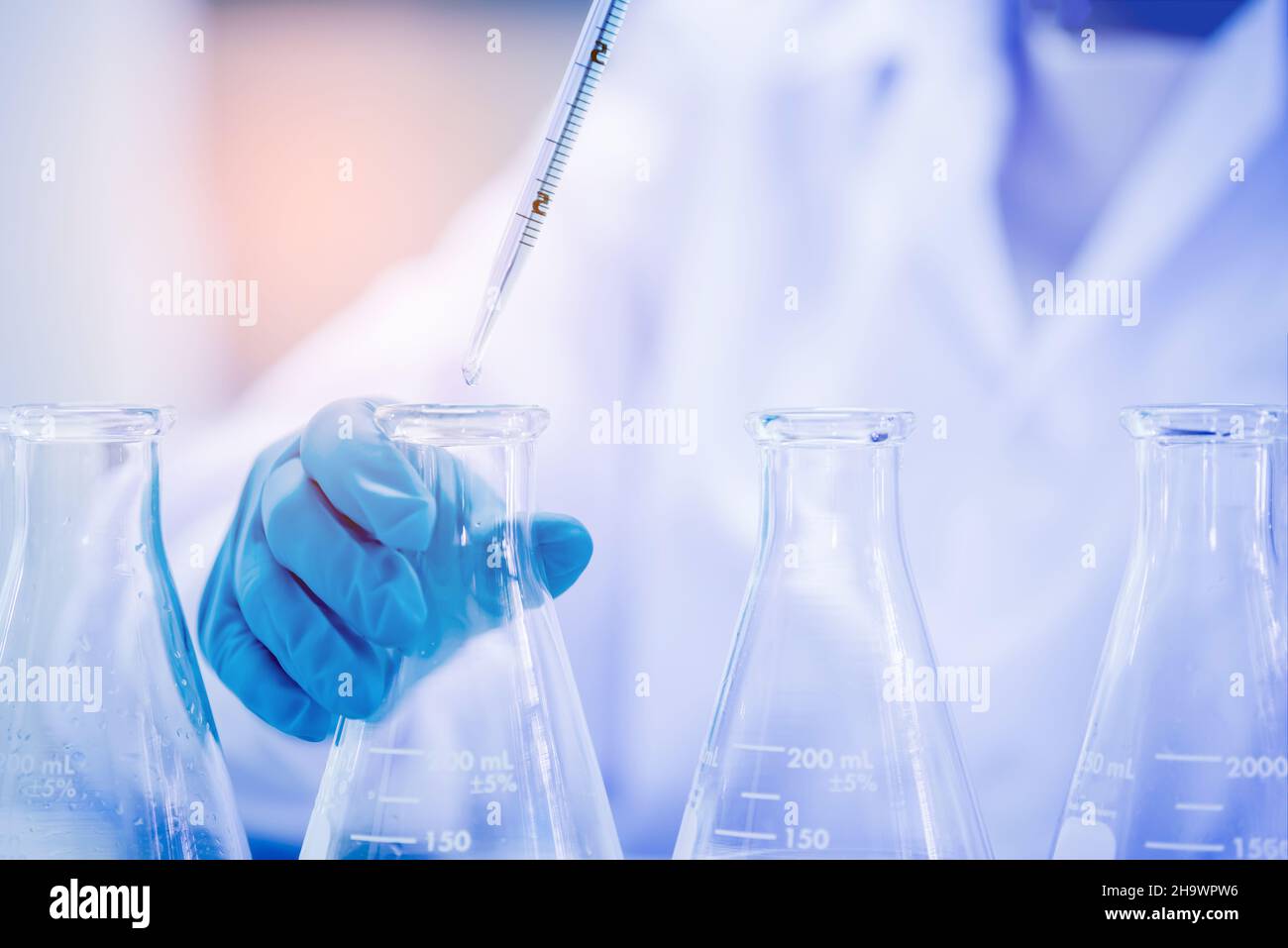 Doctor or scientist using pipette to drop a sample to test tube in ...