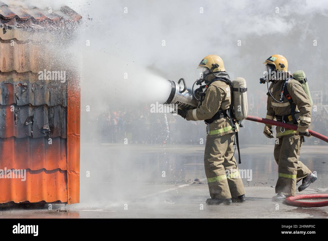 Two firefighters extinguishes fire from fire hose using firefighting ...
