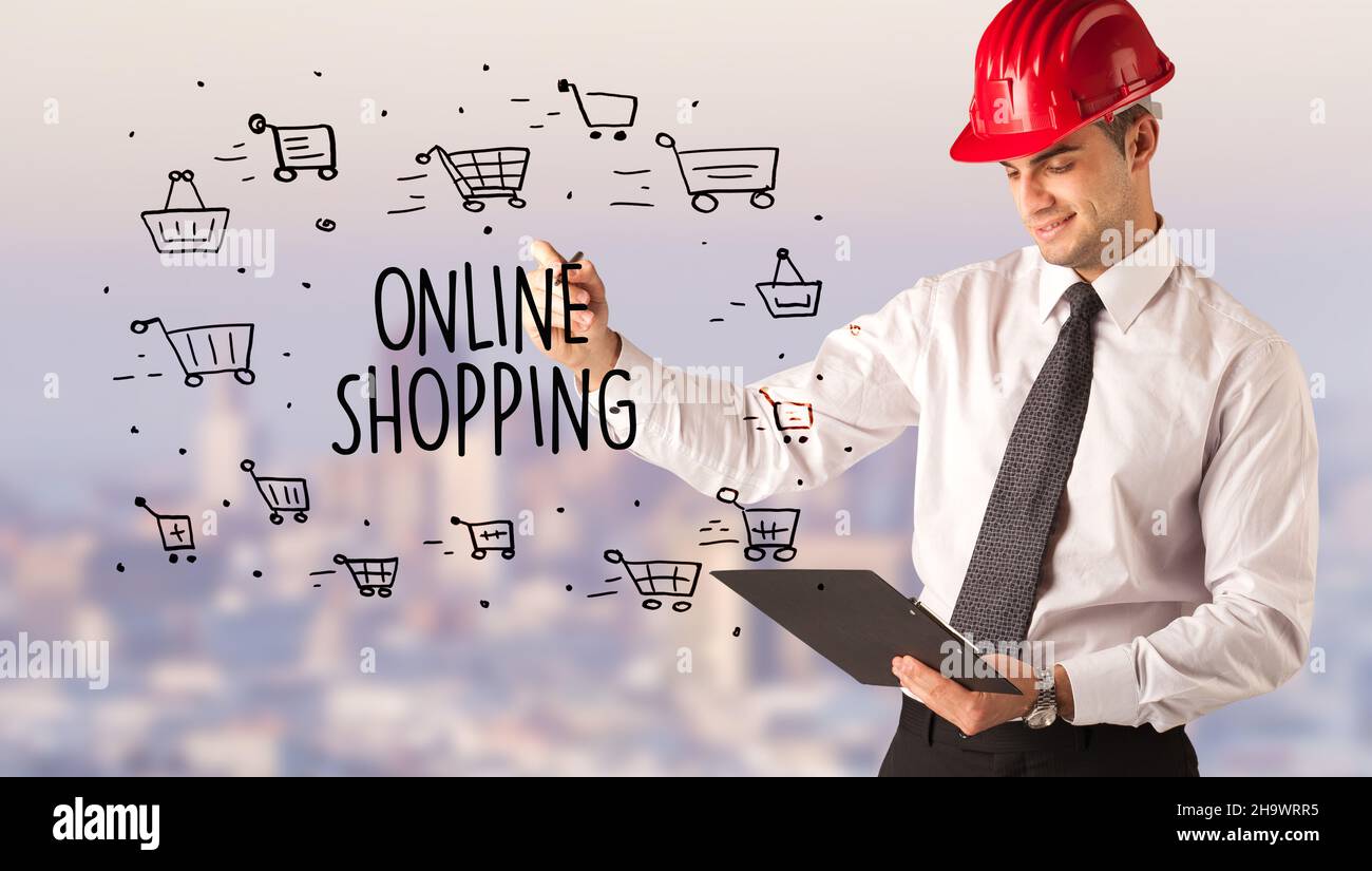 Young businessman with helmet drawing sale sign Stock Photo - Alamy
