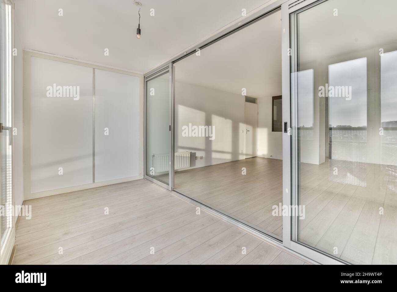 Open modern glass doors connecting two rooms Stock Photo - Alamy