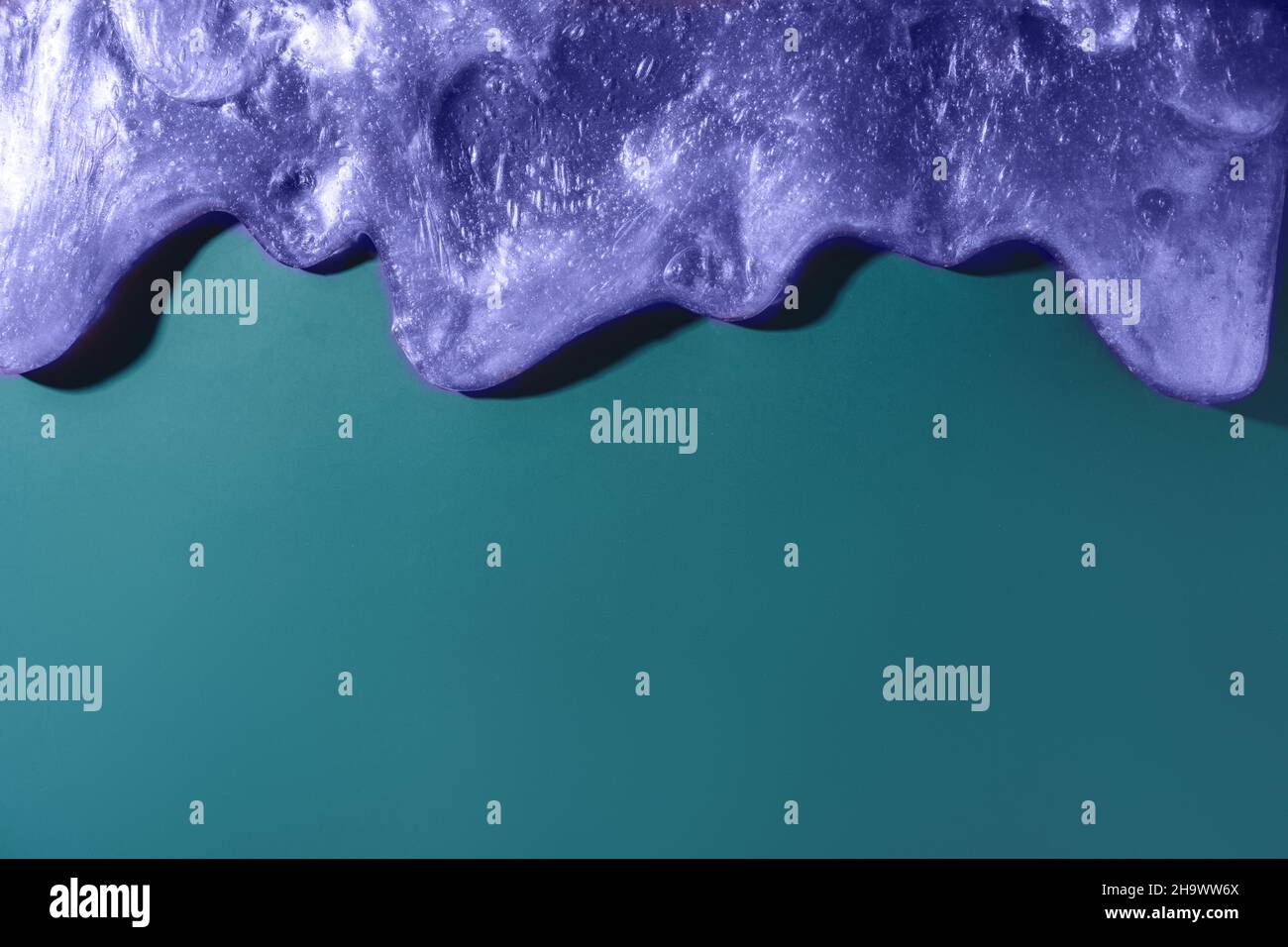 Purple liquid slime flowing over cyan background. Color of the year ...