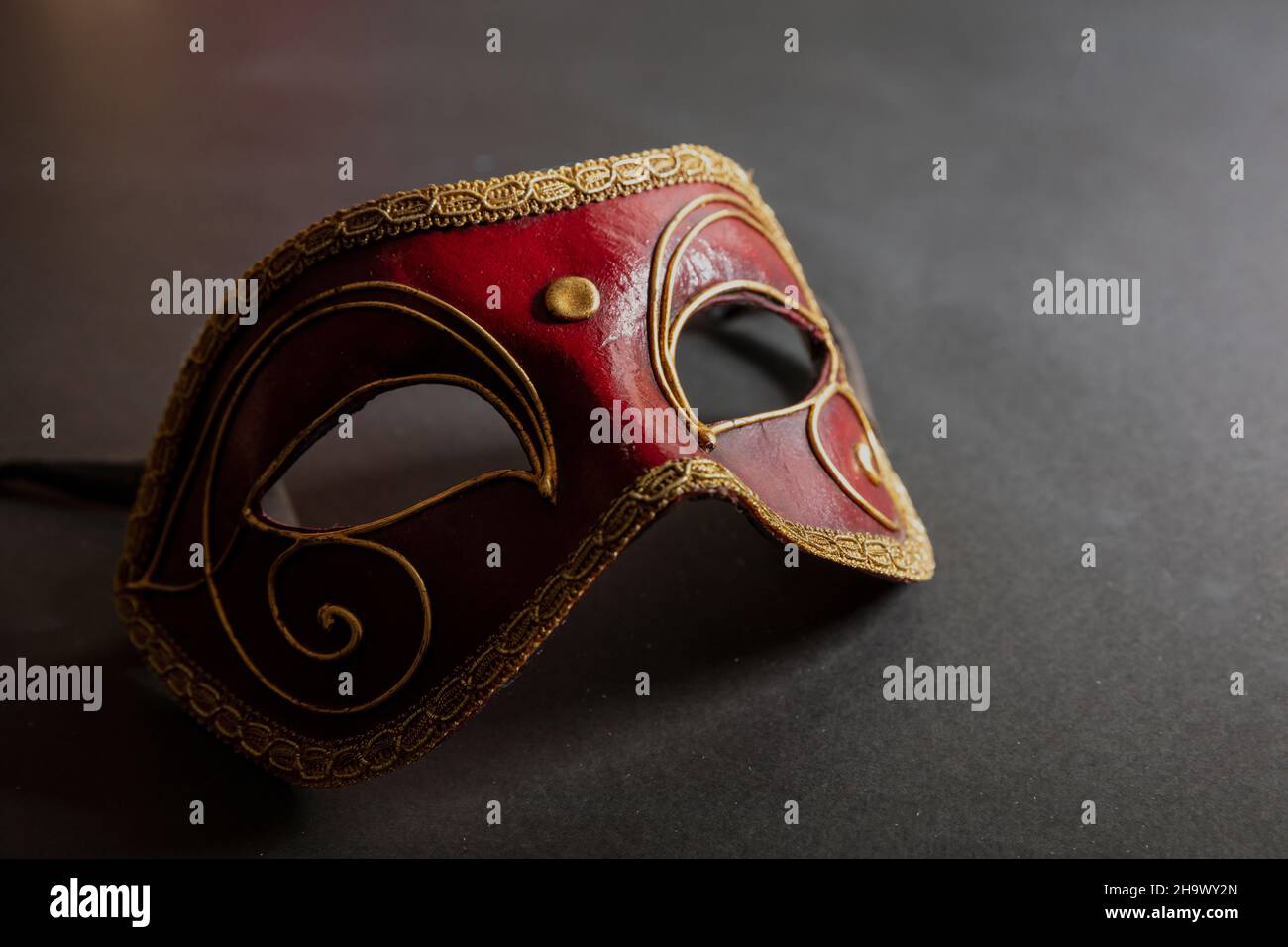 Carnival Venetian mask red color handmade on black color background. Traditional festival ...