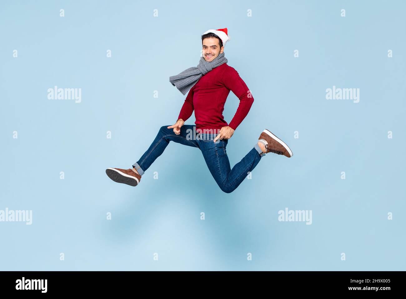 Young happy handsome Caucasian man in Christmas outfit jumping in ...