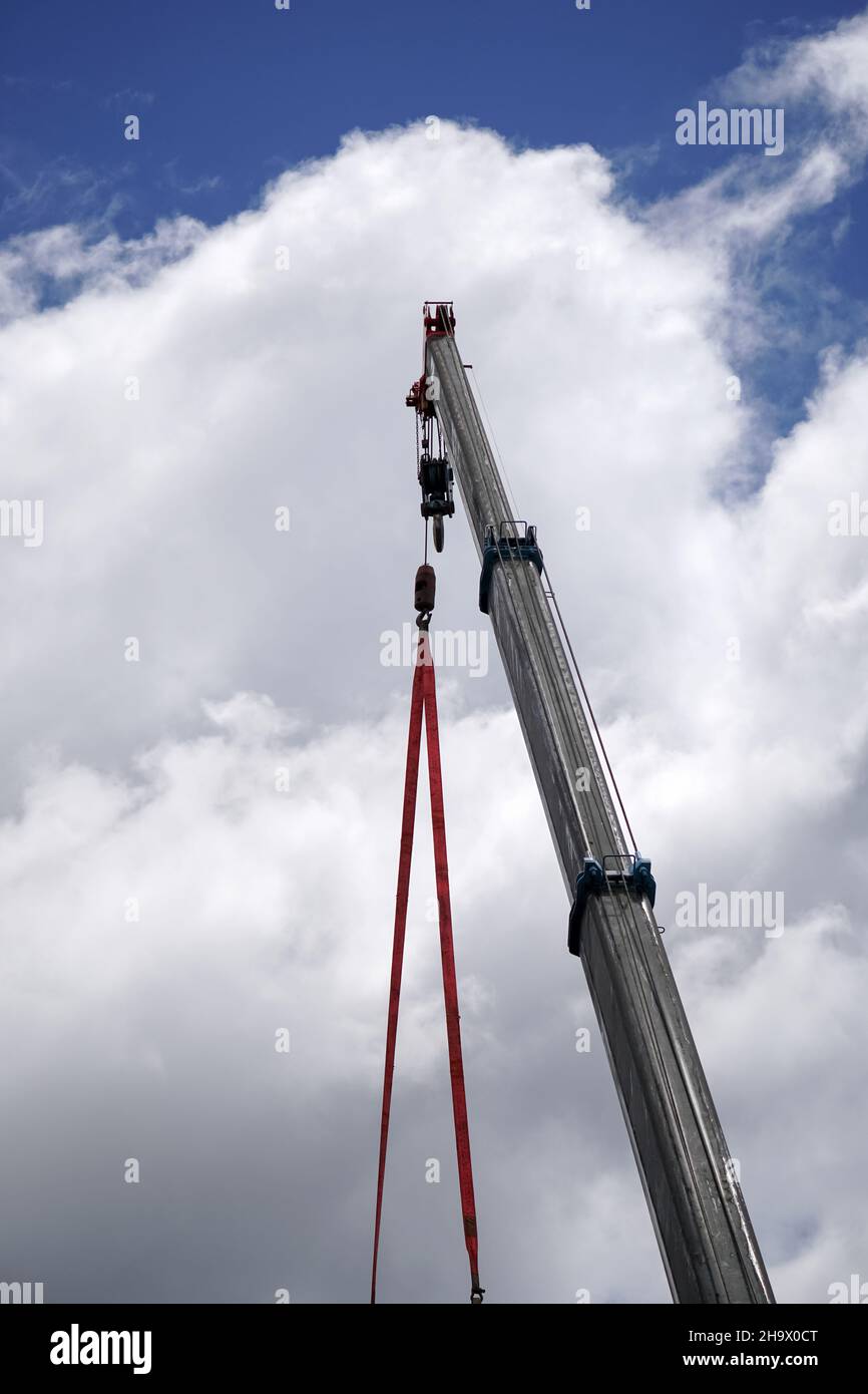 Industrial Crane operating and lifting an construction material in site ...