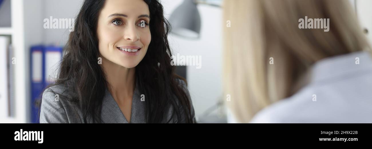 Two business women discussing at table in office Stock Photo - Alamy