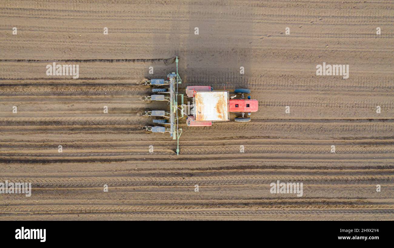 Above top view, of tractor as pulling mechanical seeder machine over ...