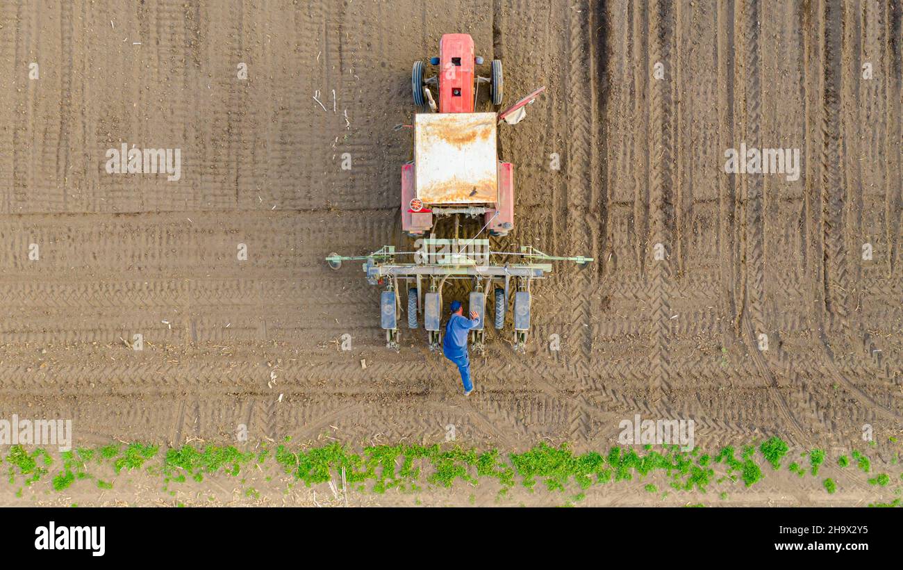 Above top view, shot of worker is check or adjust seed drill ...