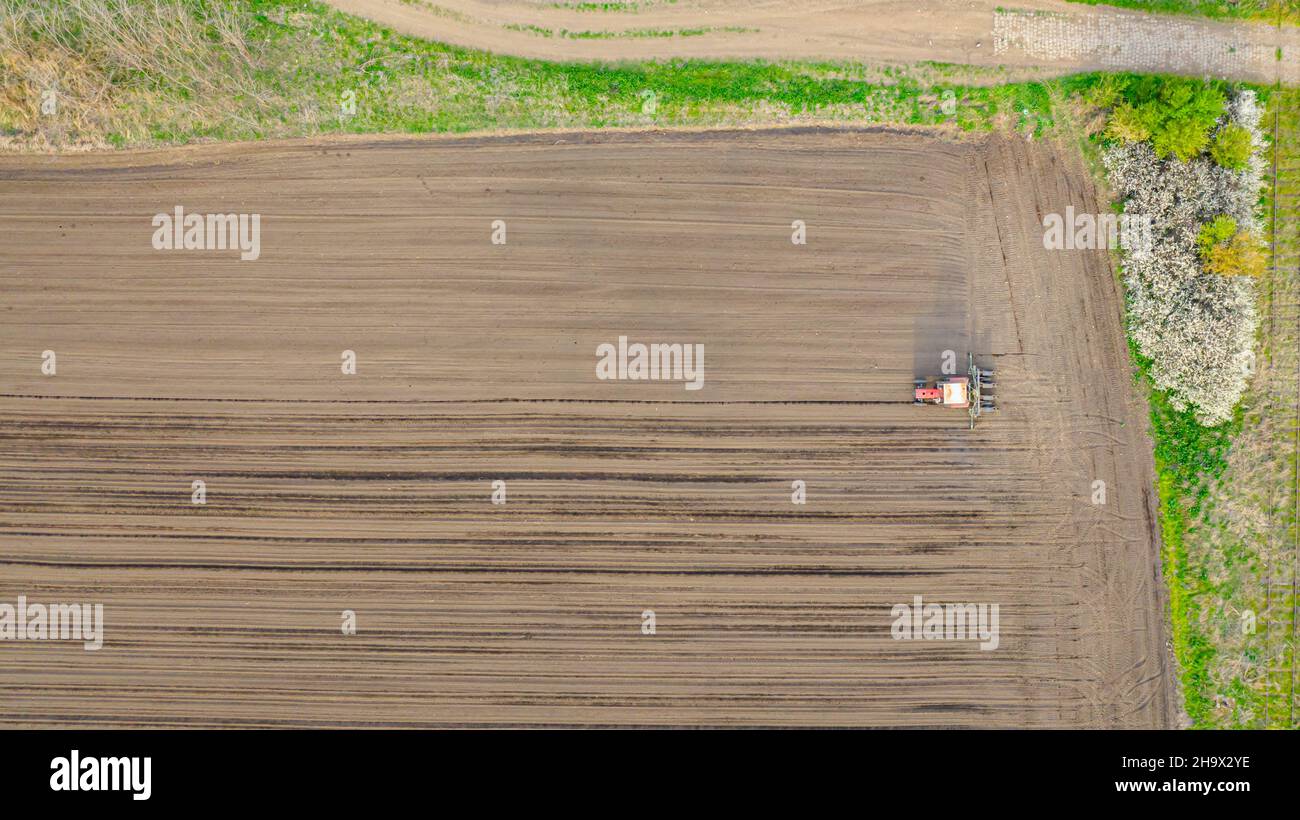 Above top view, of tractor as pulling mechanical seeder machine over ...