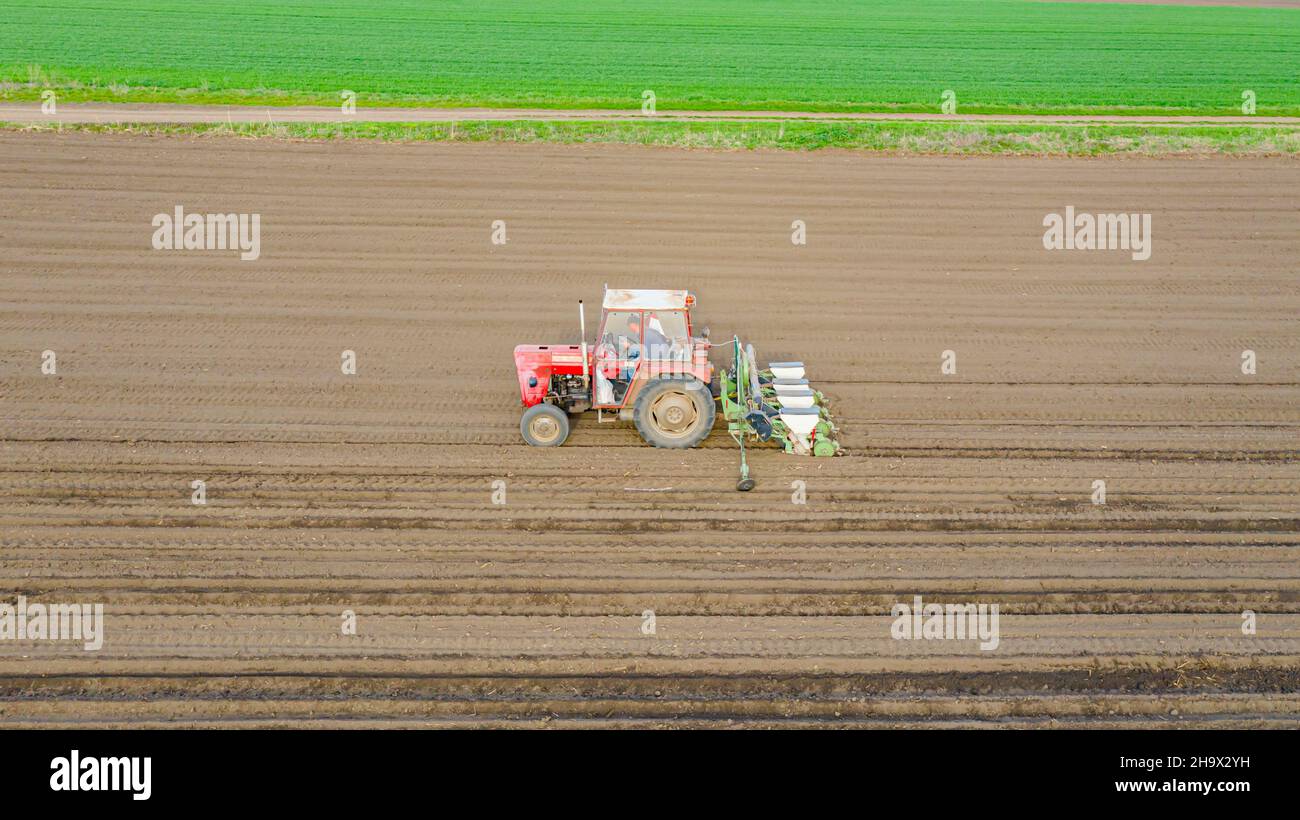Above sidelong view, of tractor as pulling mechanical seeder machine ...