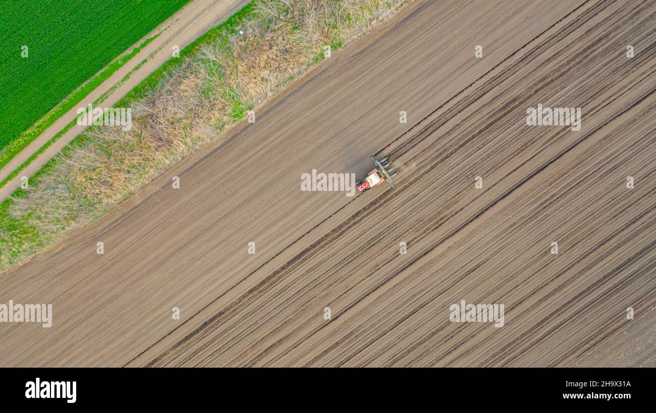 Above top view, of tractor as pulling mechanical seeder machine over ...