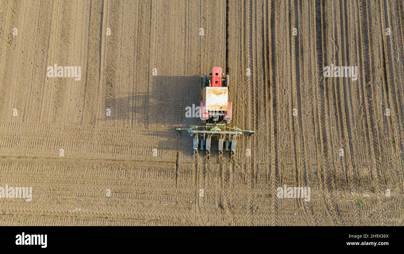Above top view, of tractor as pulling mechanical seeder machine over ...