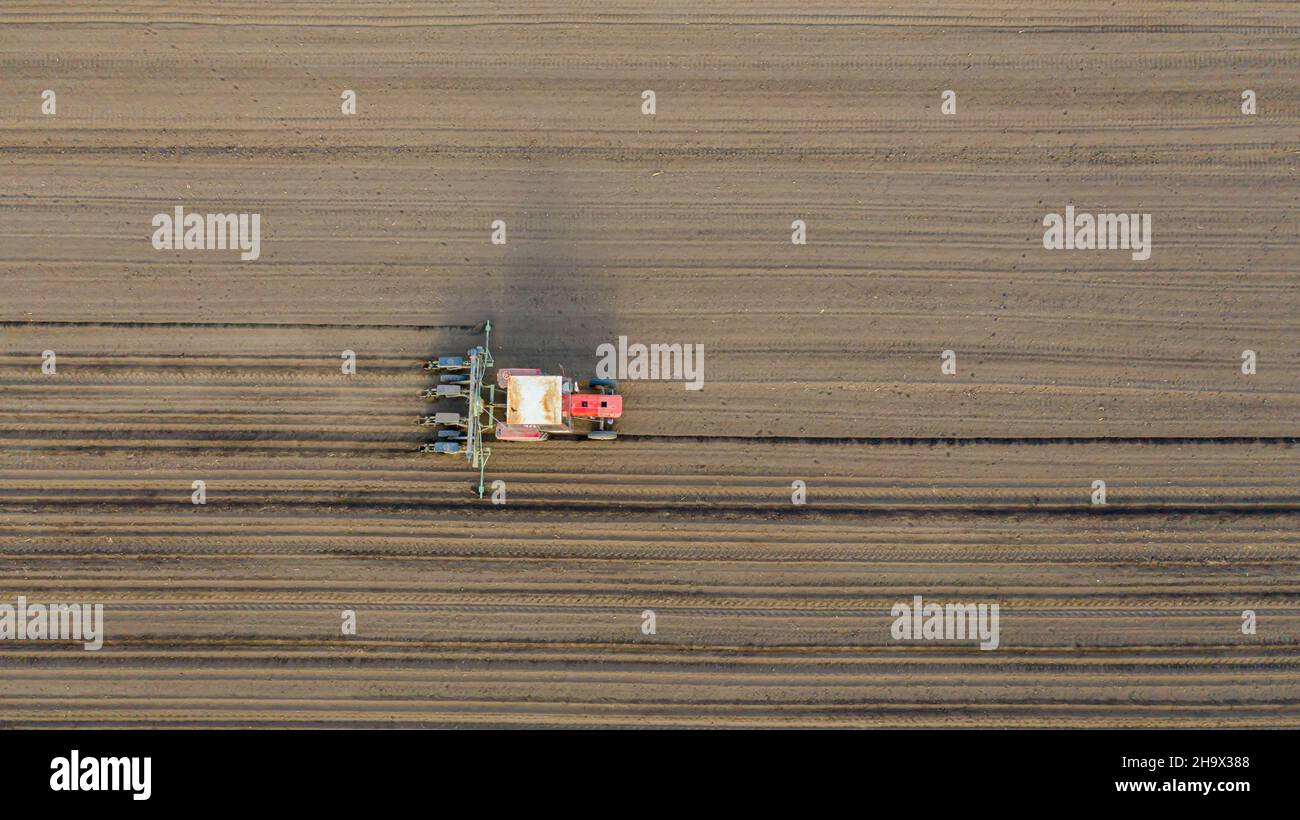 Above top view, of tractor as pulling mechanical seeder machine over ...