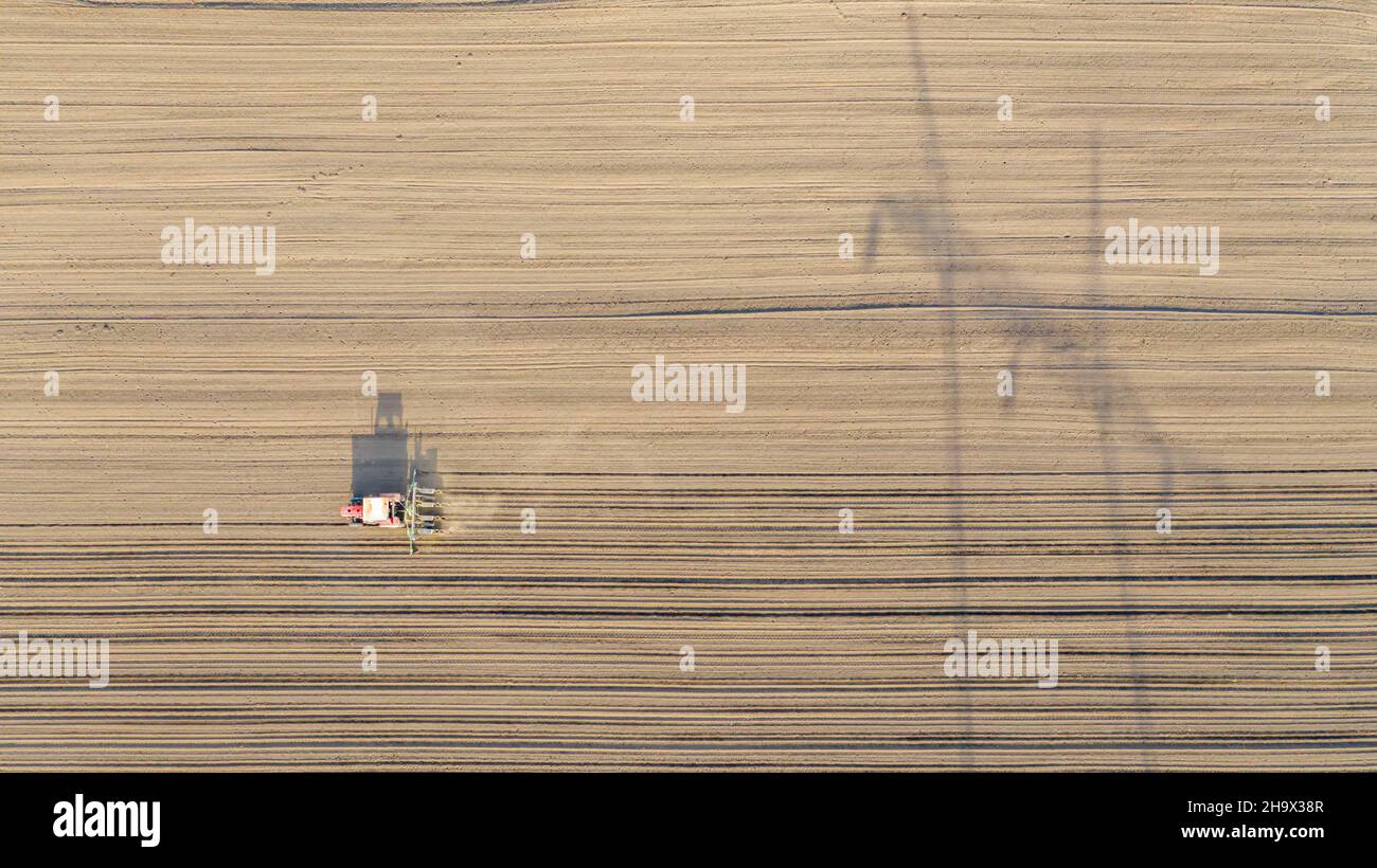 Above top view, of tractor as pulling mechanical seeder machine over ...