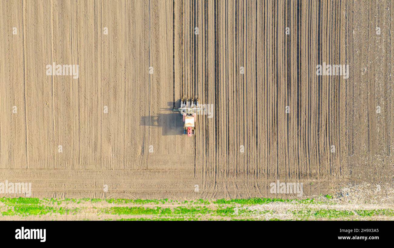 Above top view, of tractor as pulling mechanical seeder machine over ...