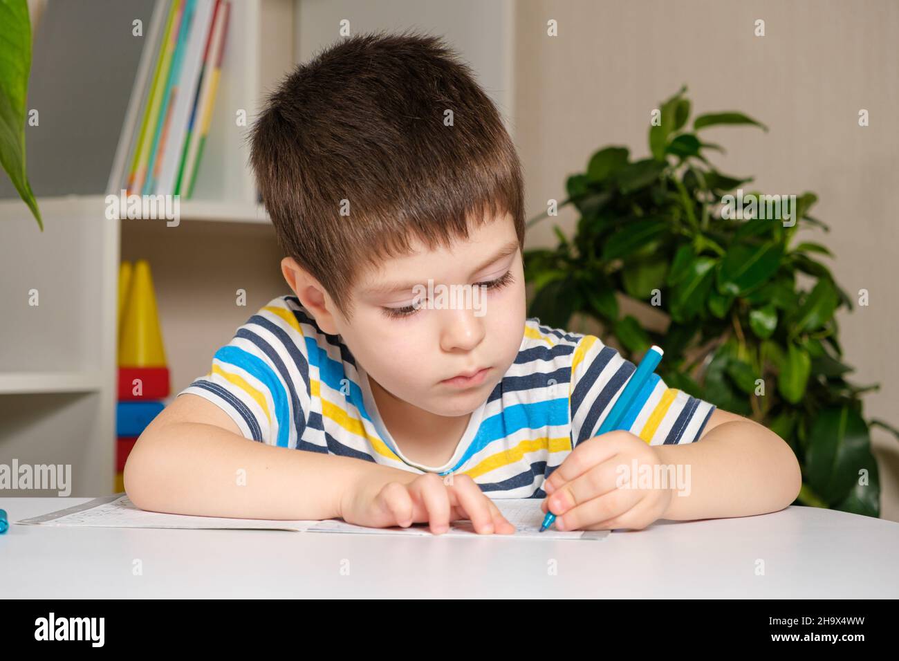 Preschool child learns to write, writes copybook Stock Photo - Alamy