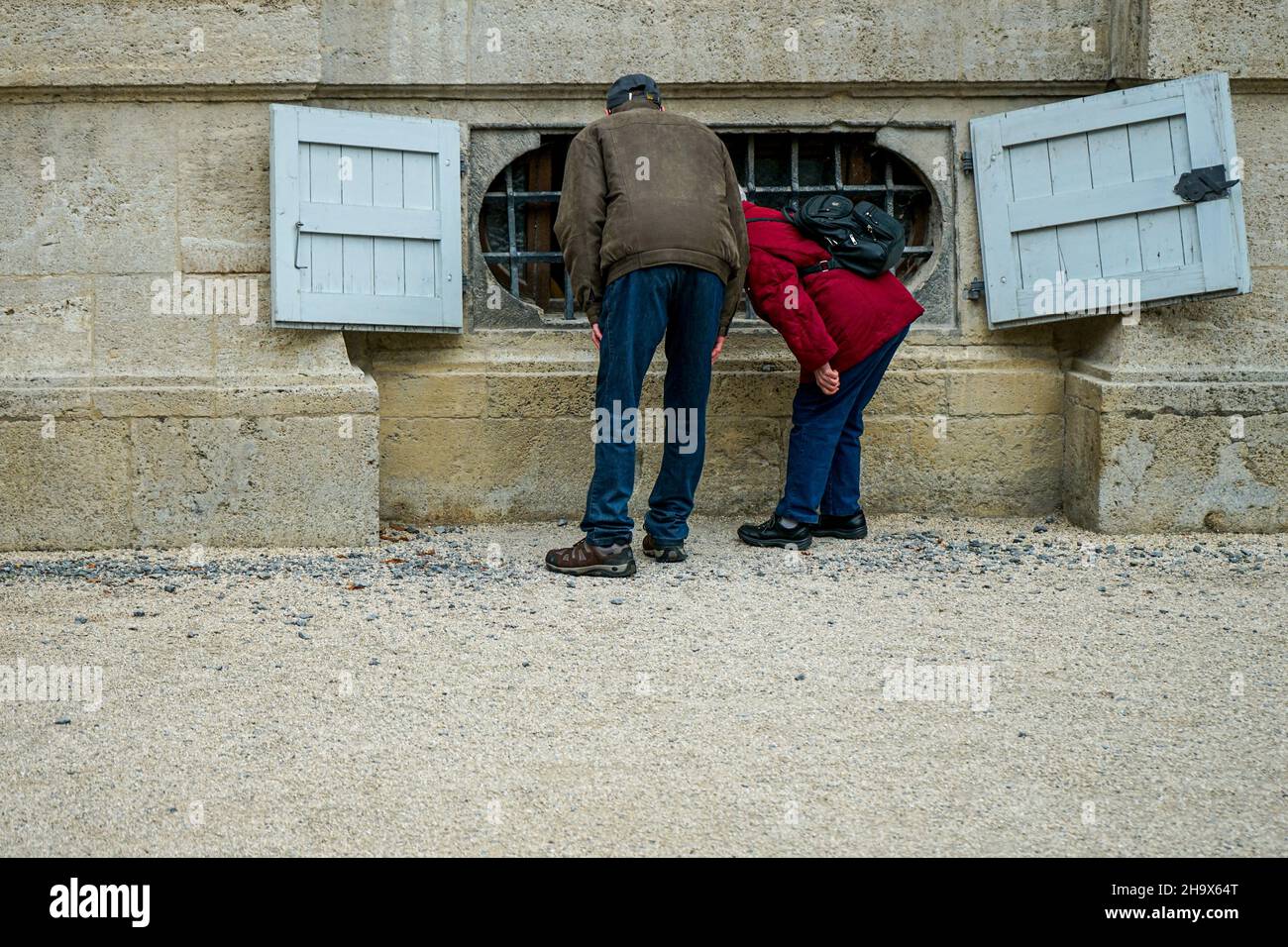 A couple looks through a window into an interior room of the Würzburg ...