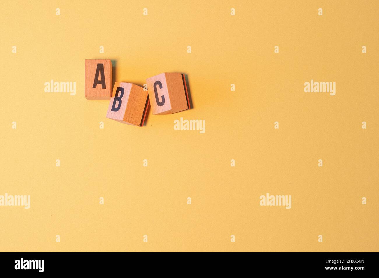 "ABC" word composed with wooden letter blocks in the yellow background ...
