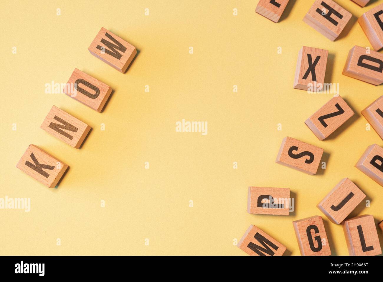 Word KNOW, taken from a pile of wooden letter blocks with yellow ...
