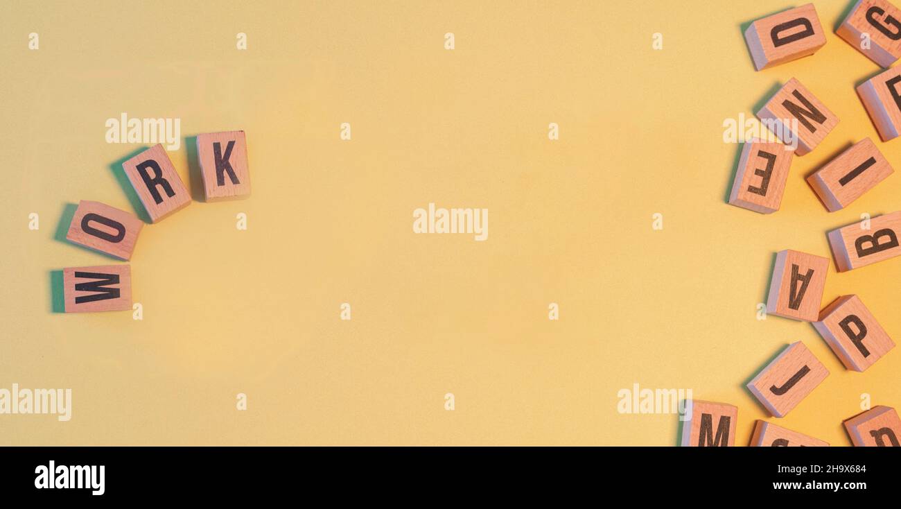 Word WORK, taken from a pile of wooden letter blocks with yellow ...