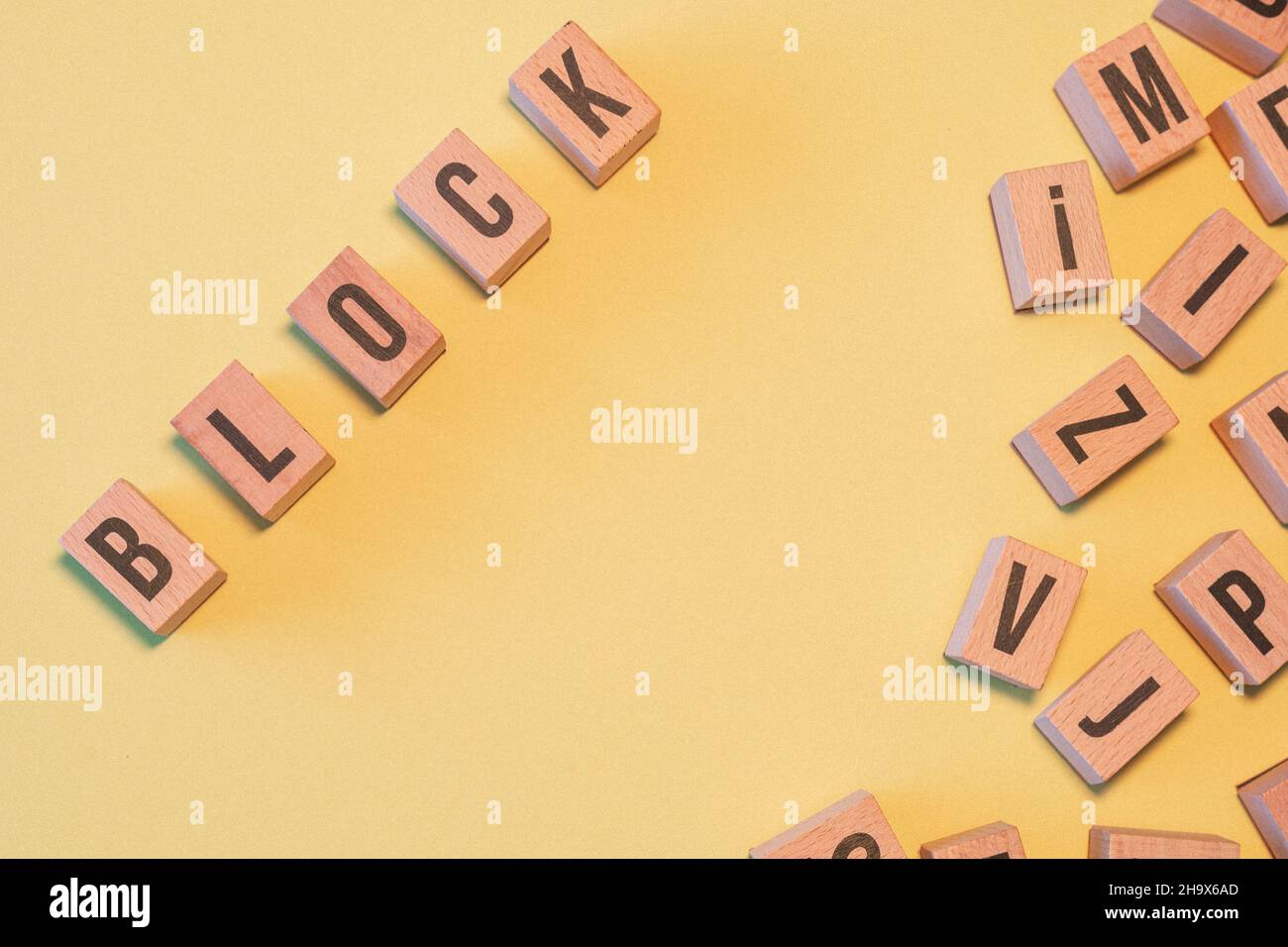 Word BLOCK, taken from a pile of wooden letter blocks with yellow ...