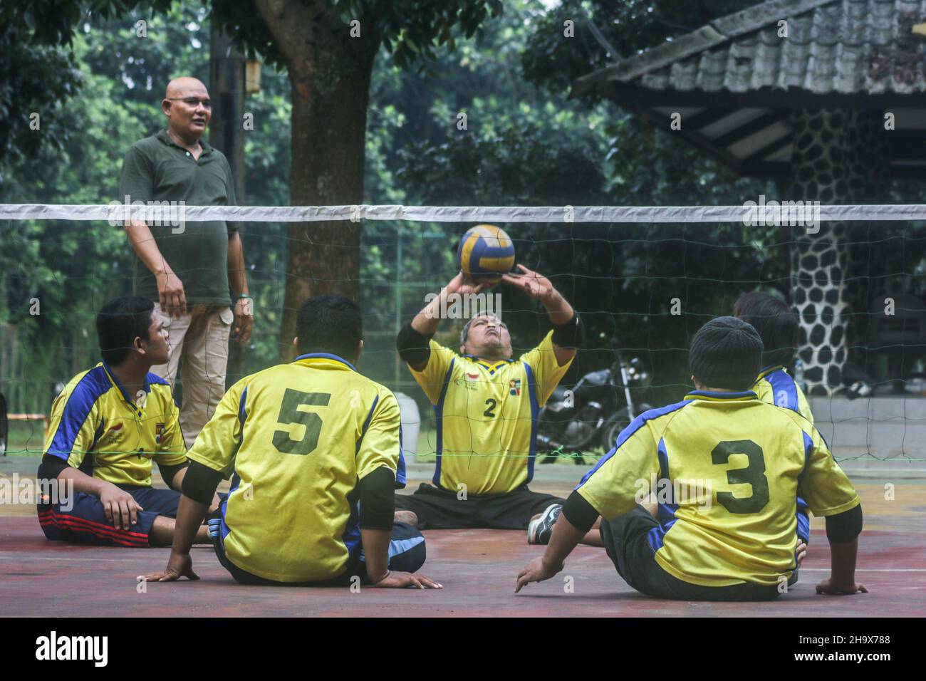 athletes with disabilities practice sitting volleyball on the indoor ...