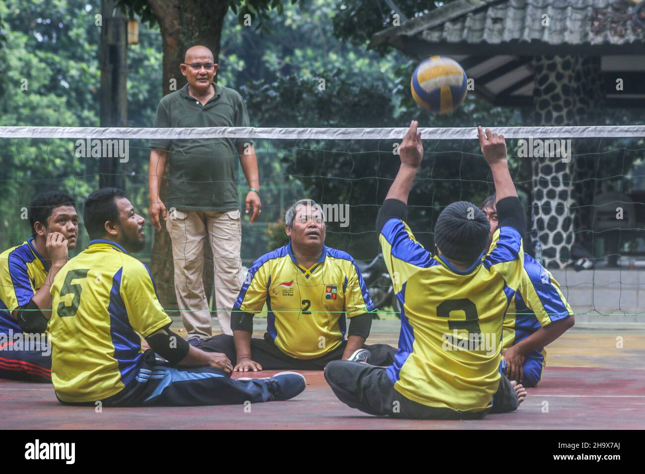 athletes with disabilities practice sitting volleyball on the indoor ...